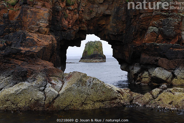 Stock photo of View of coast through rock arch, Papa Stour island ...