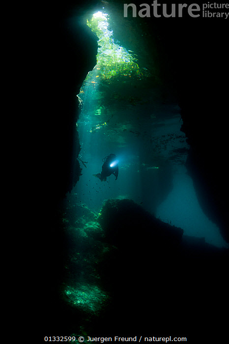 Stock photo of Light streaming into a shallow cave in a dive site ...