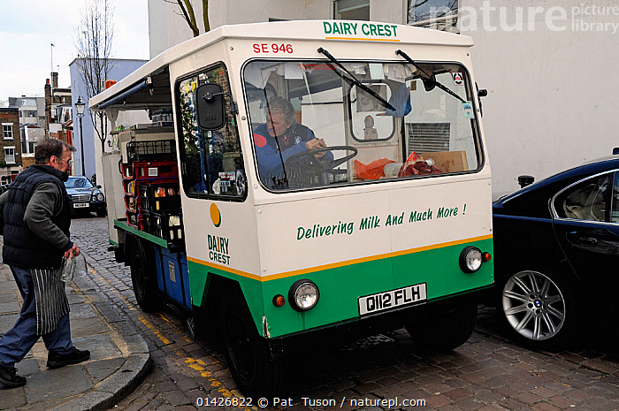 Stock photo of Electric milk float with milkman delivering milk ...
