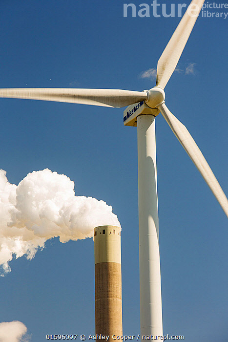 Stock photo of Wind turbine with stacks of coal fired power station in ...