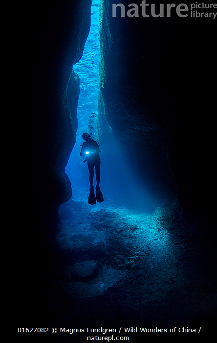 Stock photo of Taiwanese diver exploring a shallow cave, Green Island ...