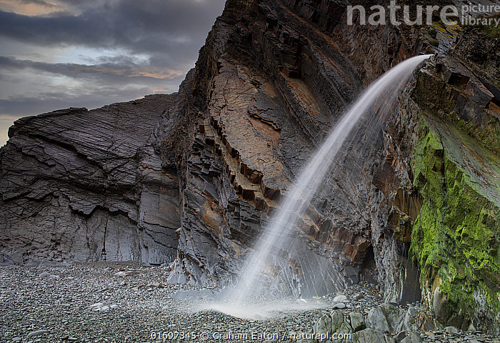 Stock photo of A small waterfall cascading over steeply dipping beds of ...